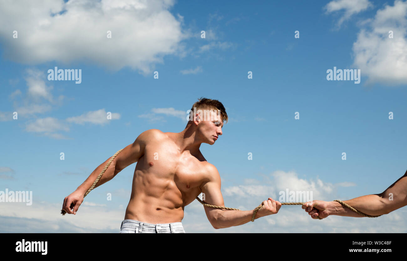 Challenging himself. Strong man pulls opposite end of rope. Fit man ...