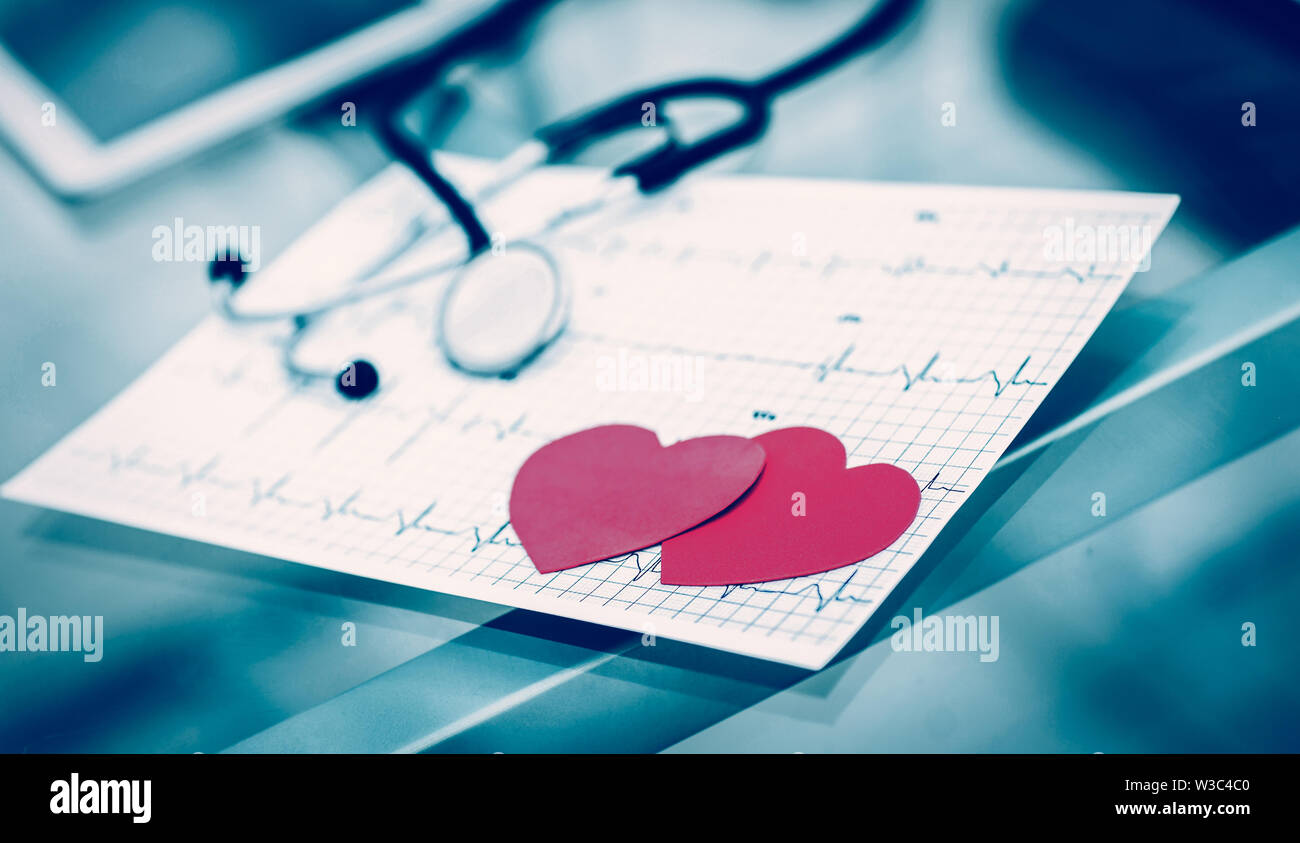 two red paper heart on the electrocardiogram, the cardiologist.the ...