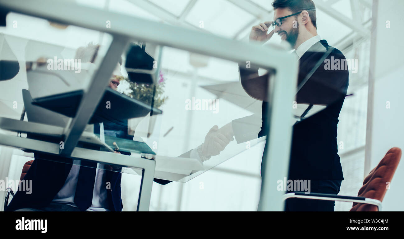 handshake of employees in the workplace in a modern office.the photo ...