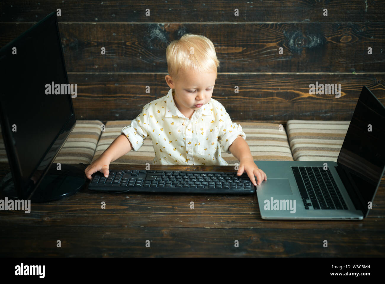 Little child use innovation in education. Baby boy typing on computer ...