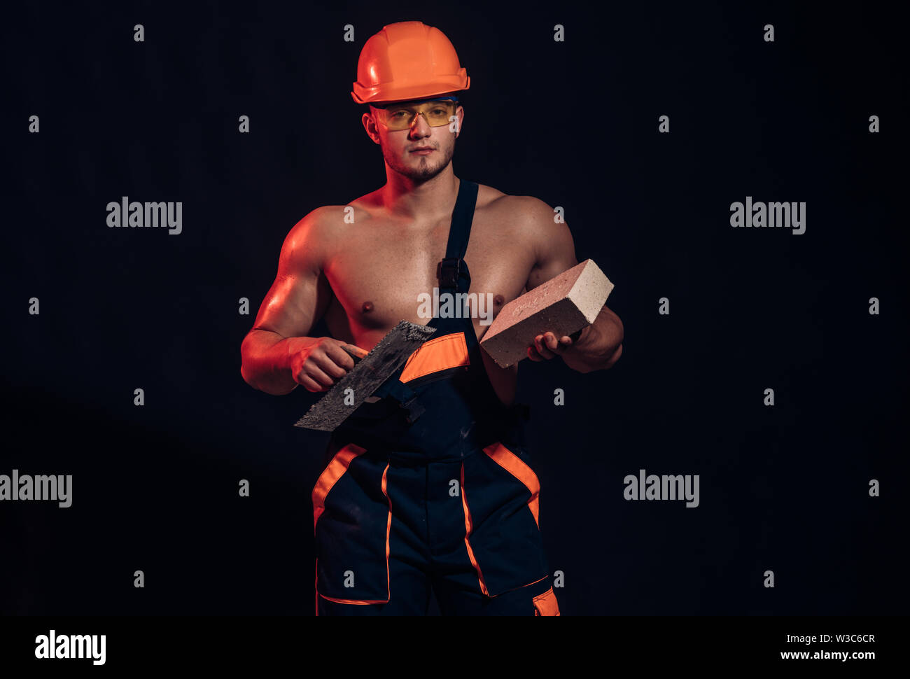 Our reputation is as solid as concrete. Muscular man does masonry work ...