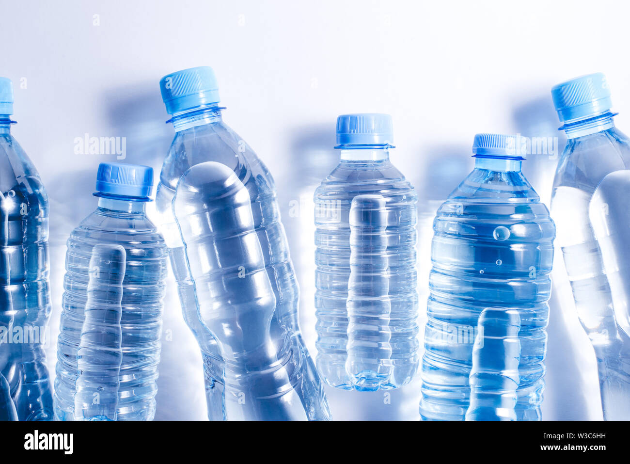 Several plastic water bottles on white background Stock Photo - Alamy