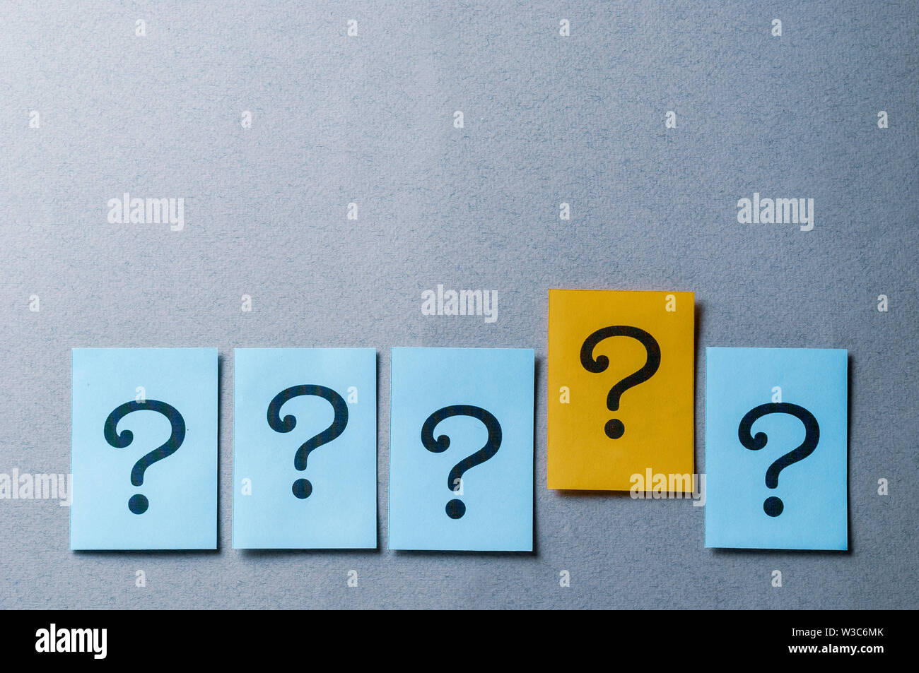 Four question marks on blue and one on yellow arranged in a line on a ...
