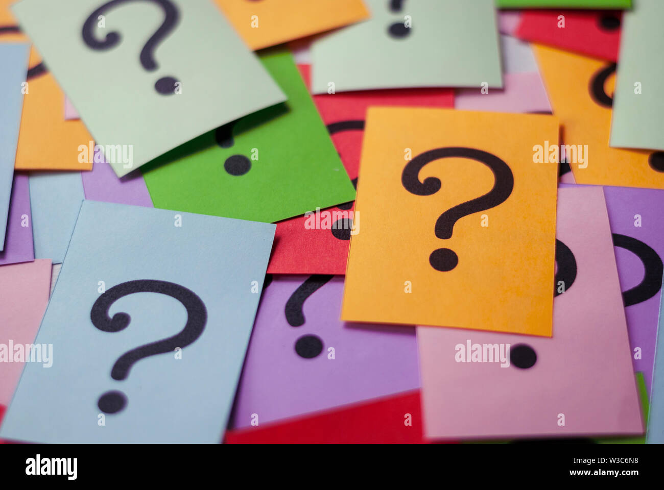 Colorful cards with printed question marks in a random scattered ...