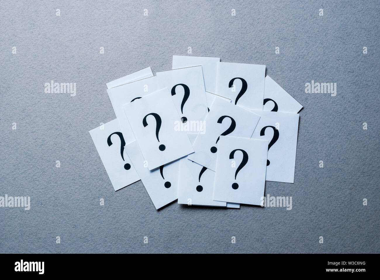 Pile of printed question marks on white paper heaped in the center on a ...