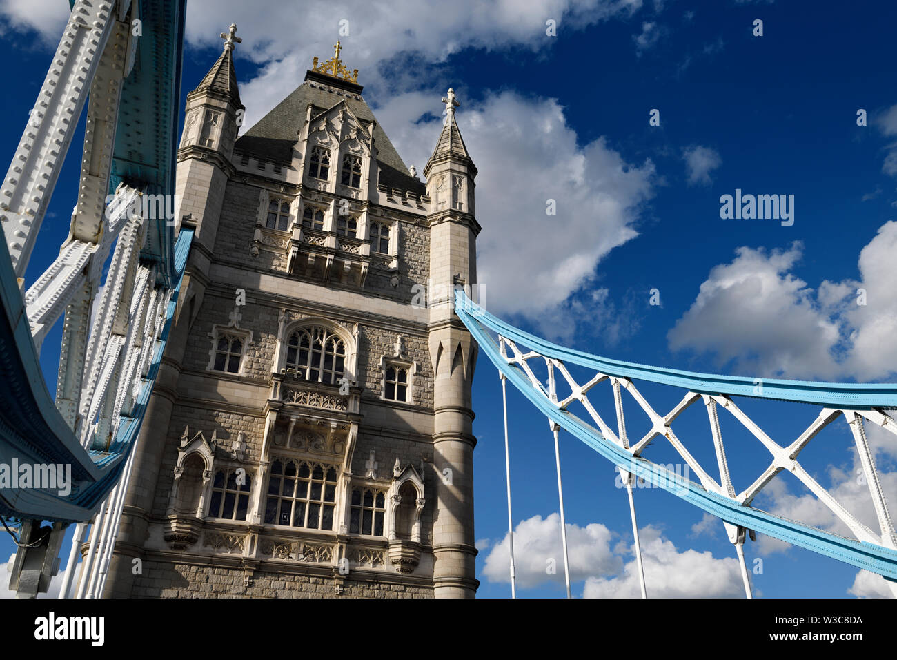 Stone tower of Tower Bridge across the Thames river in London with blue ...