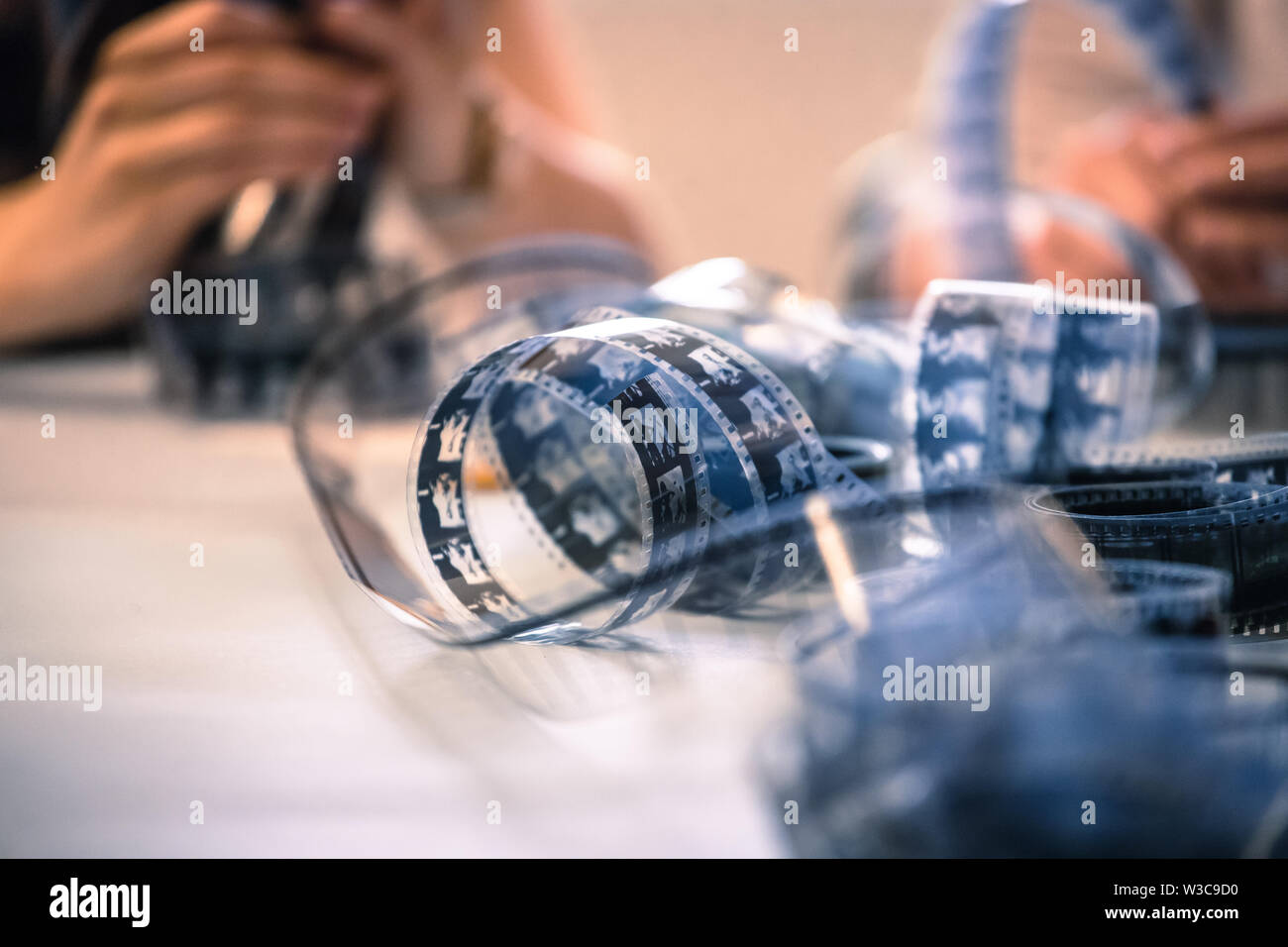 Filmmaker hands holding a film strip, cutting table Stock Photo - Alamy