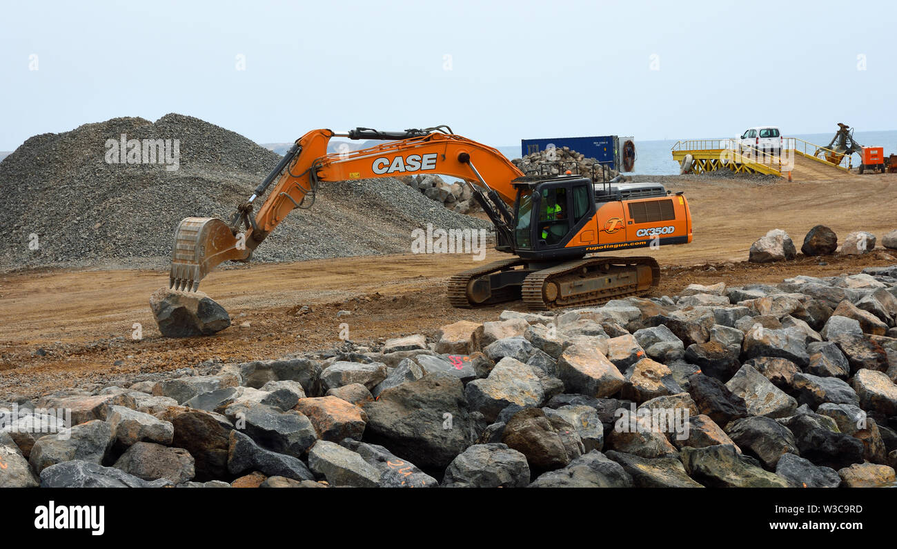 Digger moving large boulders on construction site Stock Photo - Alamy