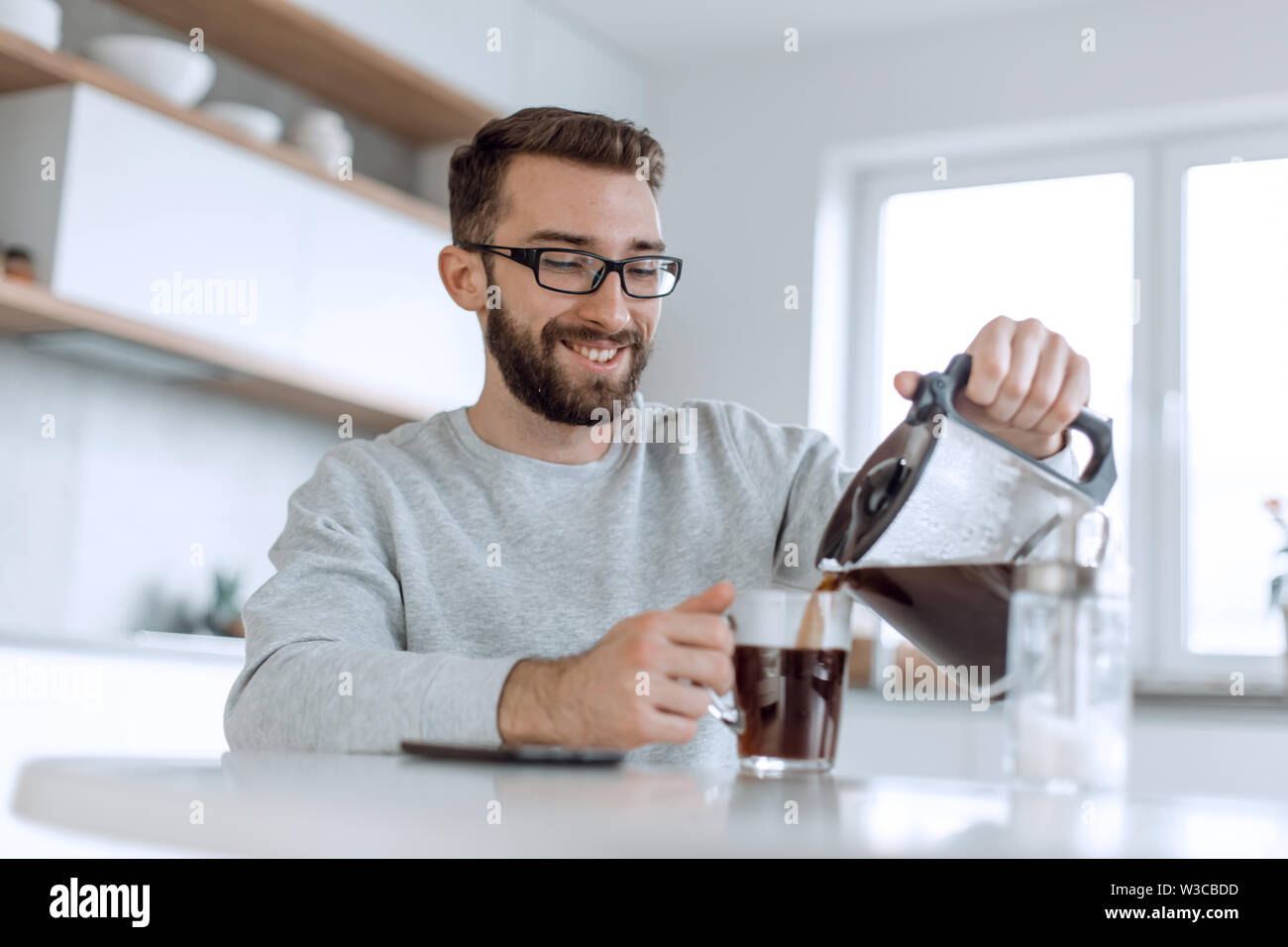 attractive man pouring himself a Cup of morning coffee Stock Photo - Alamy