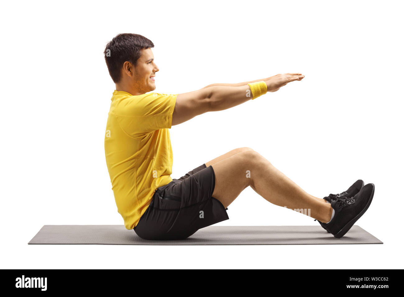 Young man exercising on an exercise mat isolated on white background ...
