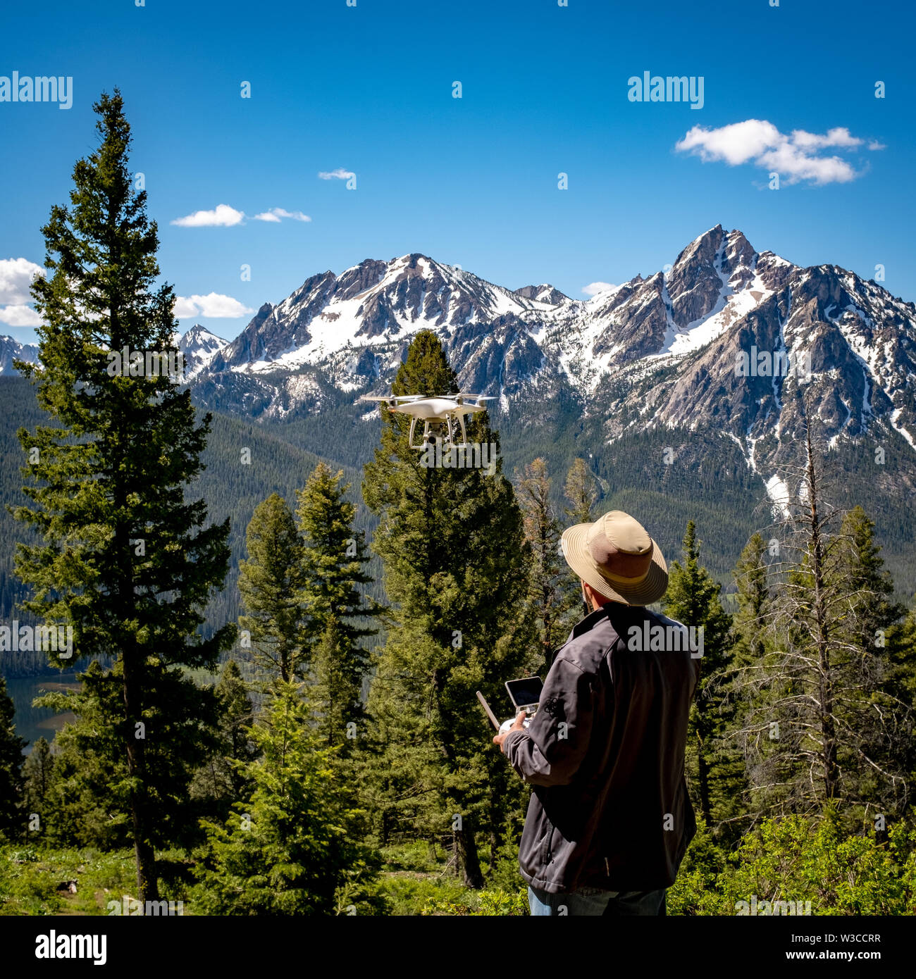 Beautiful Mountains and forest surrounds a drone pilot as he flies ...