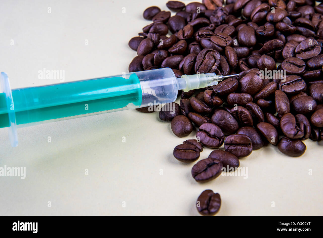Caffeine syringe with coffee beans on beige Stock Photo - Alamy