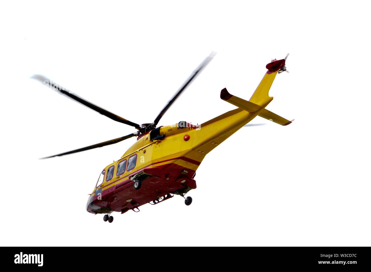 Side view to yellow emergency helicopter flying in the sky Stock Photo ...