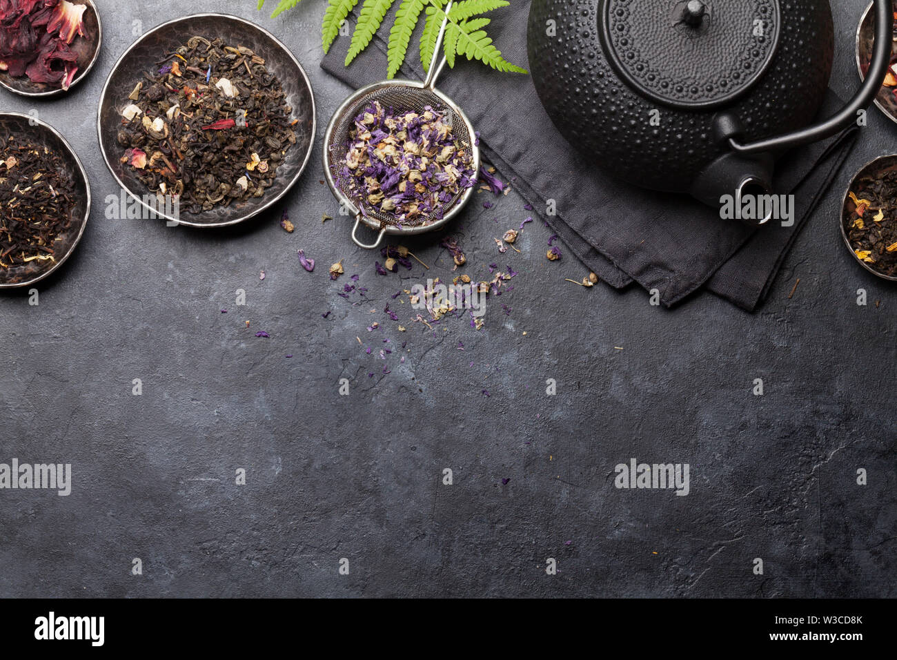 Set of different herbal and fruit dry teas on stone table. Top view ...