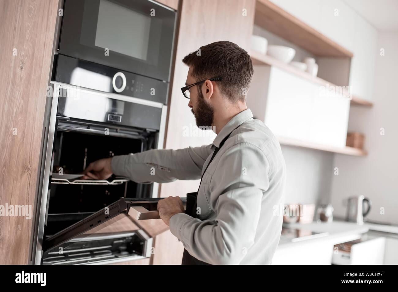 modern man opening an electric oven in his kitchen Stock Photo - Alamy