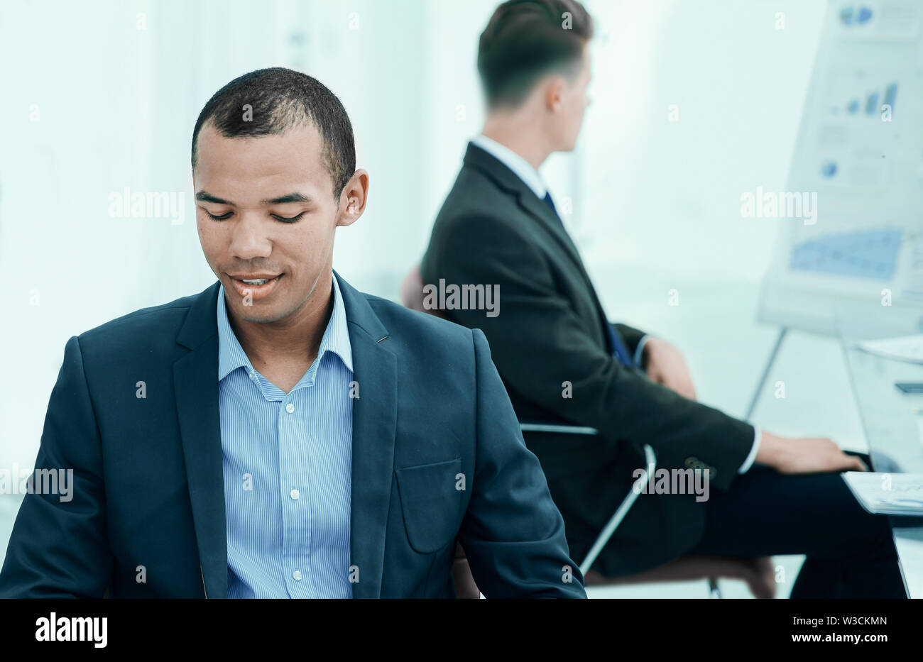 promising young employee sitting behind a Desk in the office.photo with ...