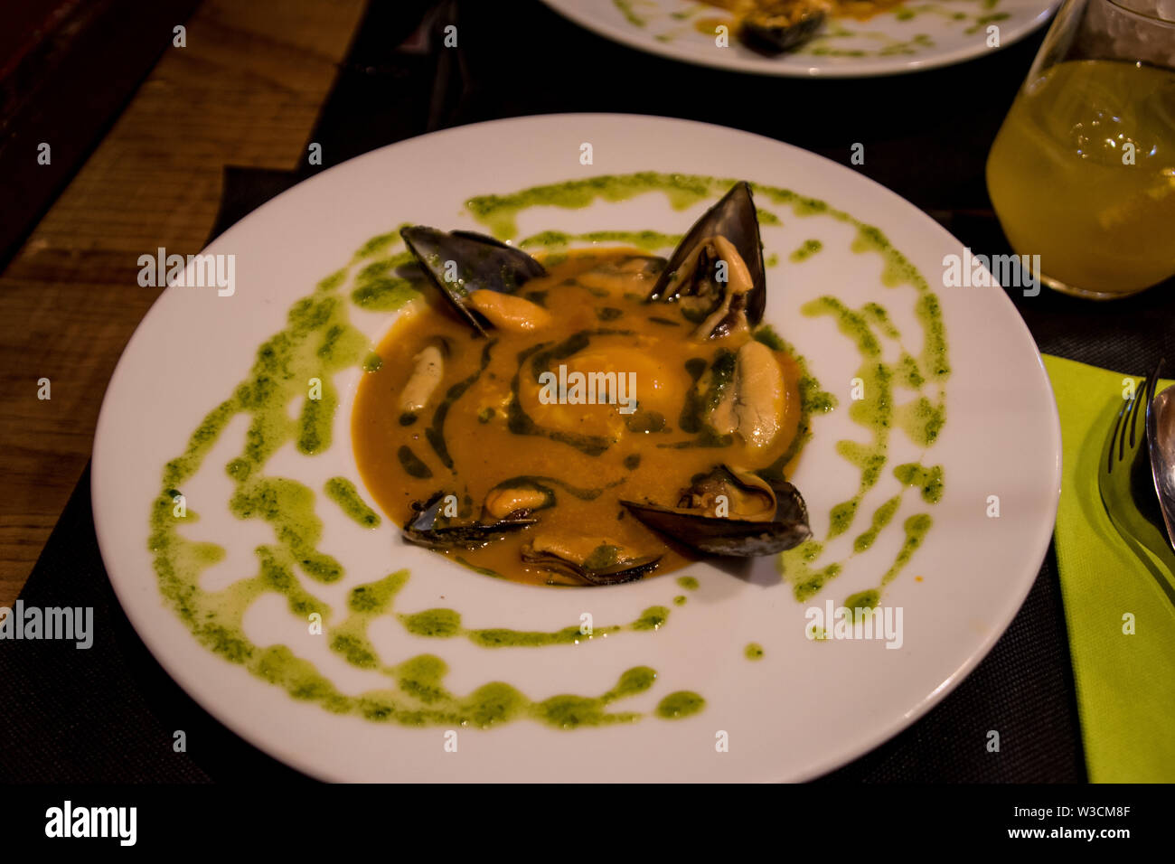 Four mussels cooked in a tomato base with green dressing Stock Photo ...