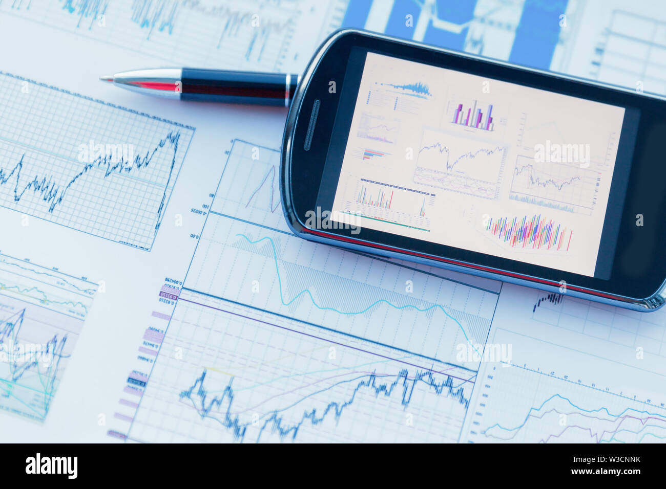 mobile phones and charts of financial growth on the desktop . business ...