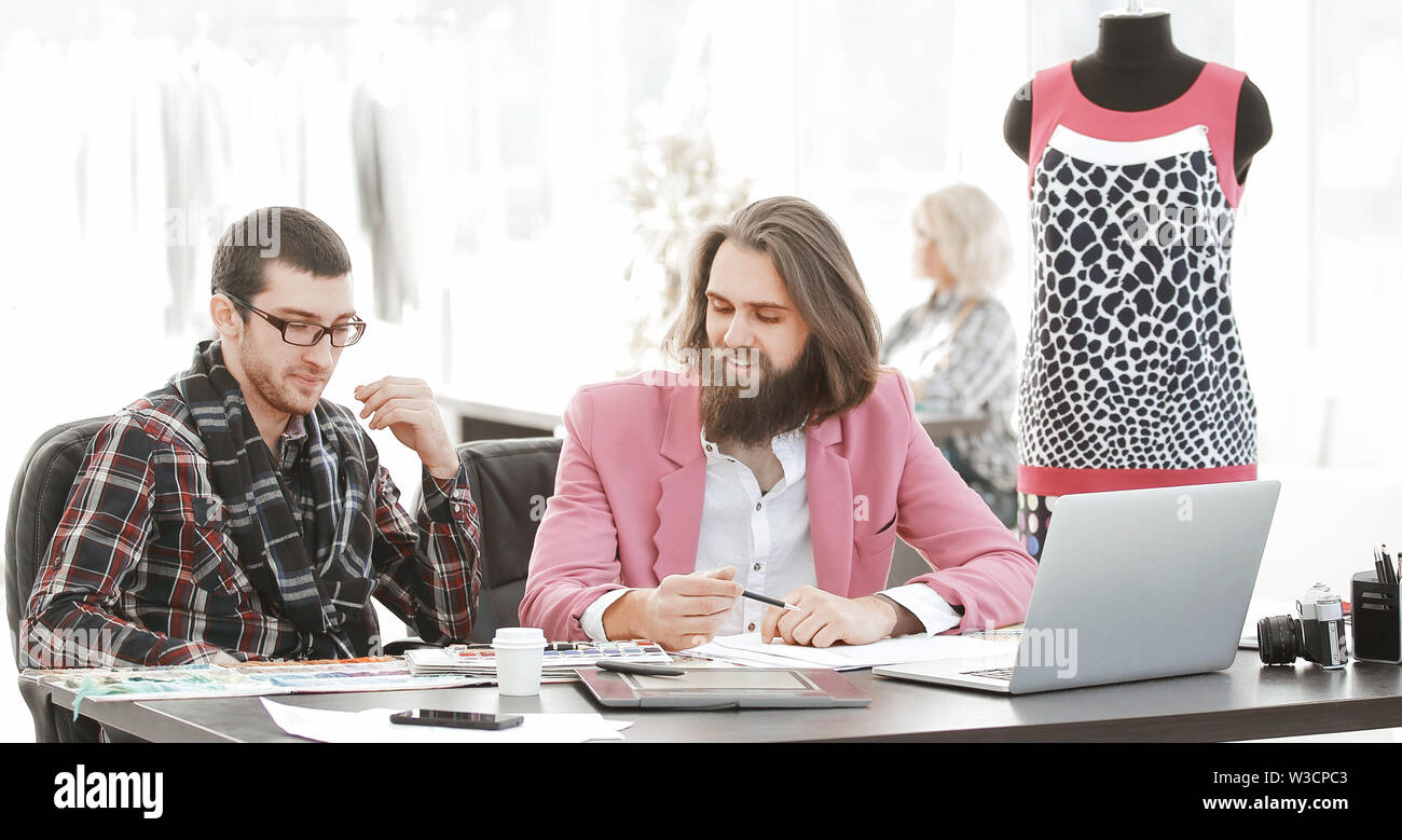 two fashion designers discussing designs of the new models Stock Photo ...