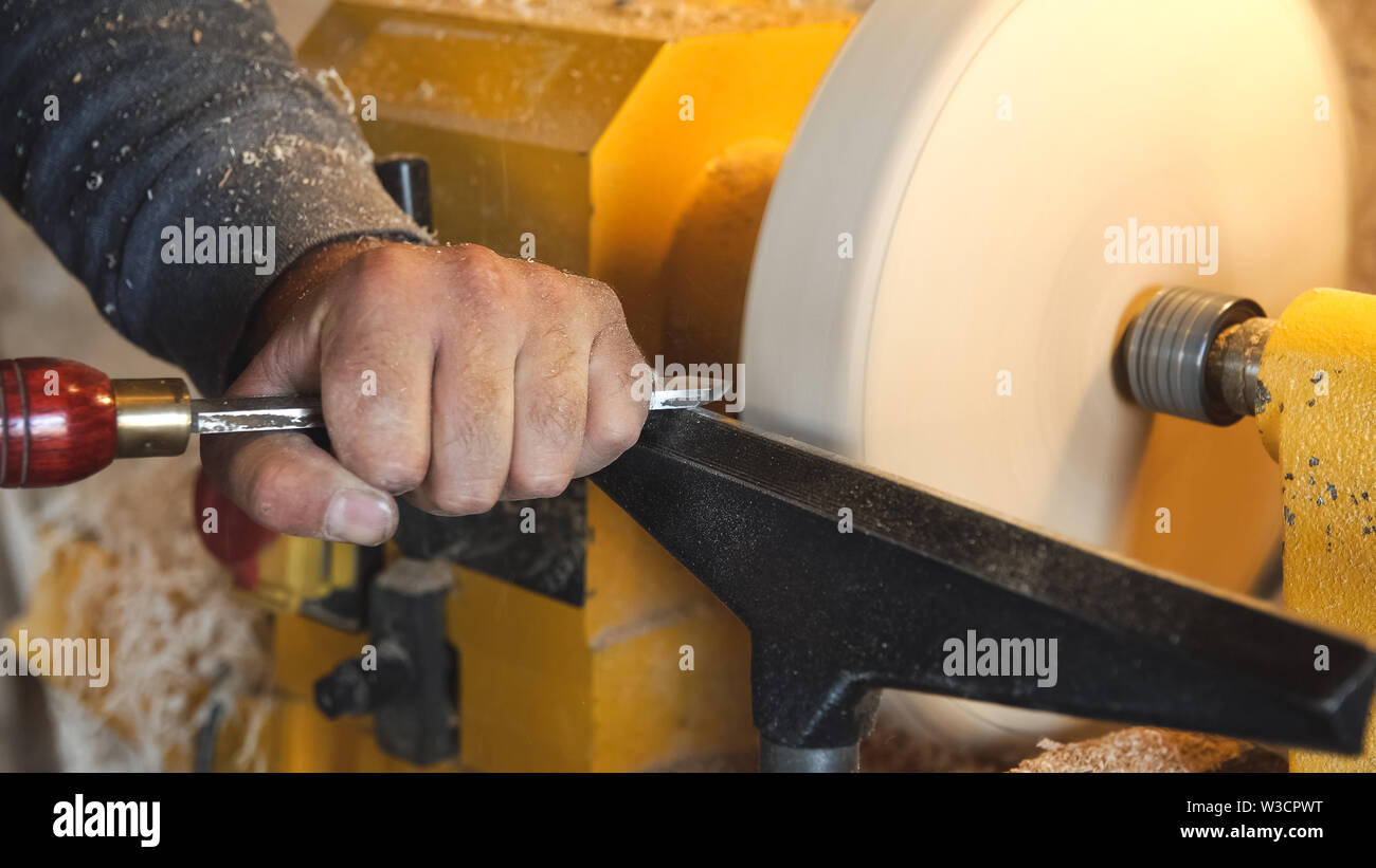 Carpenter handles wood by lathe. Builder works with the workpiece in ...