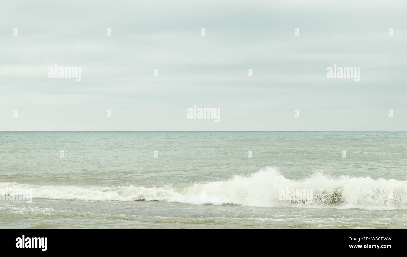 Bursts of seawater. Waves near seashore. Dark cloudy sky over sea ...