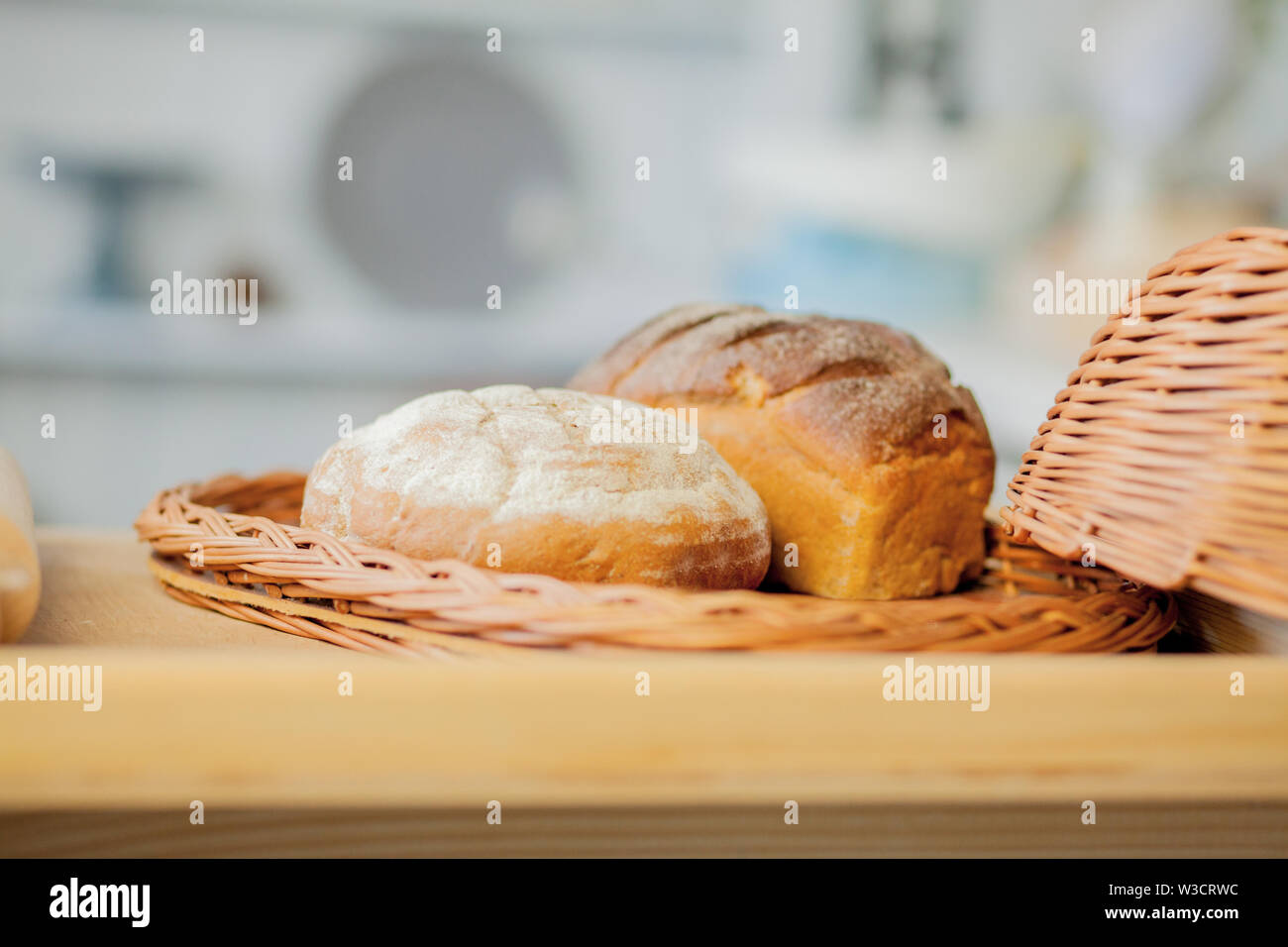 Assortment of breads near a wicker basket on a table in a rustic ...
