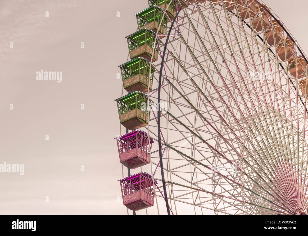 Colorful Ferris wheel in front of a blue sky. Big carousel in Gijon ...