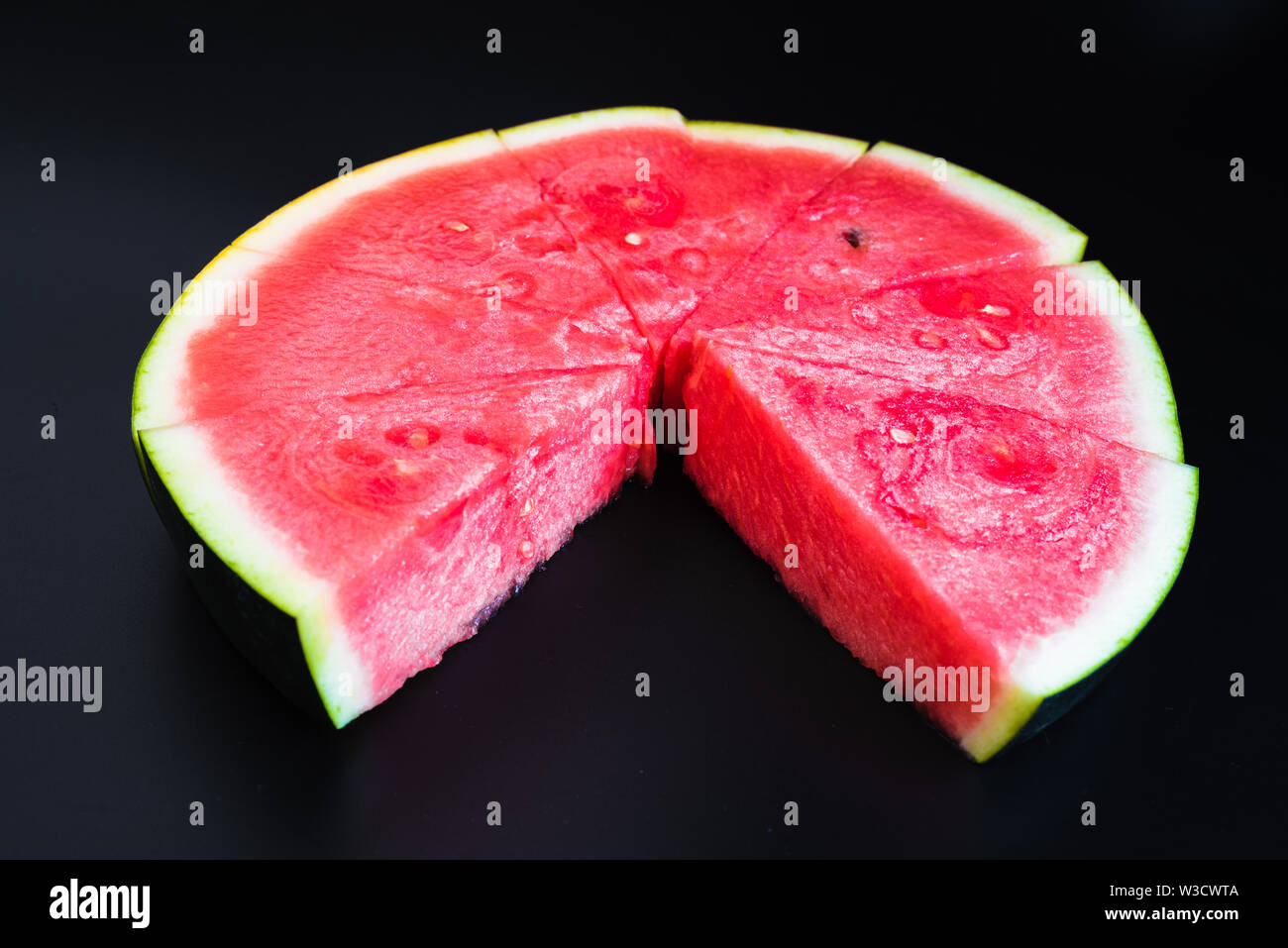 A large slice of watermelon divided into smaller pieces, flat, red ...