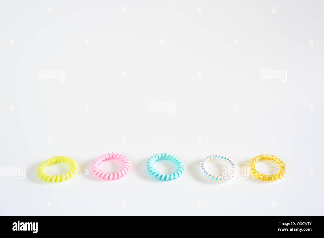 Plastic bracelets of various colors, isolated in a pattern arranged in ...