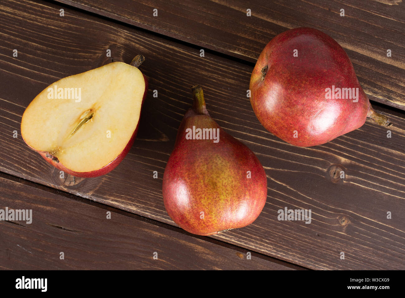 Group of two whole one half of fresh dark red pear anjou flatlay on ...