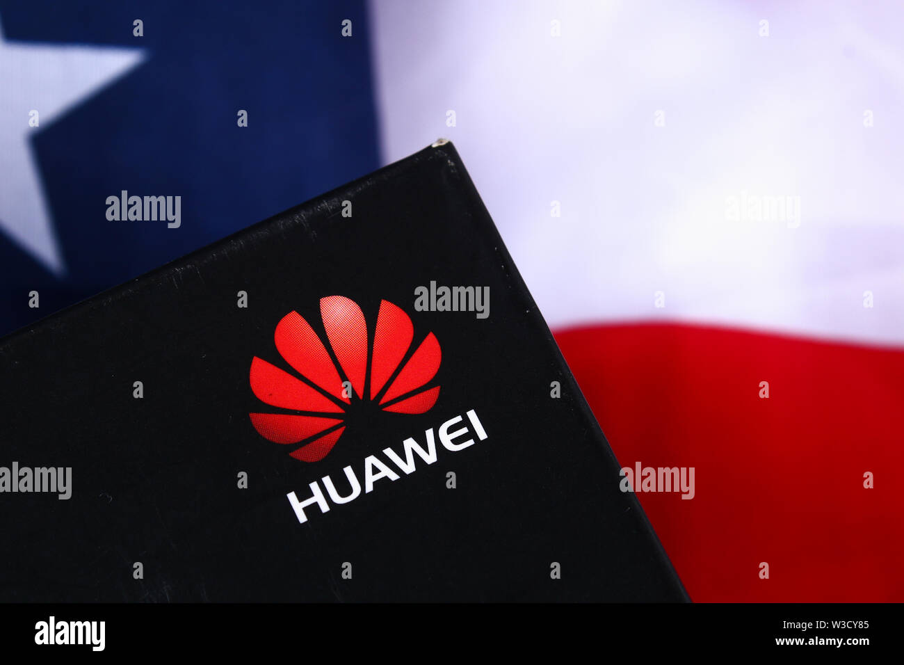 Mobile phone company Huawei on background of flag and USA dollars. The ...