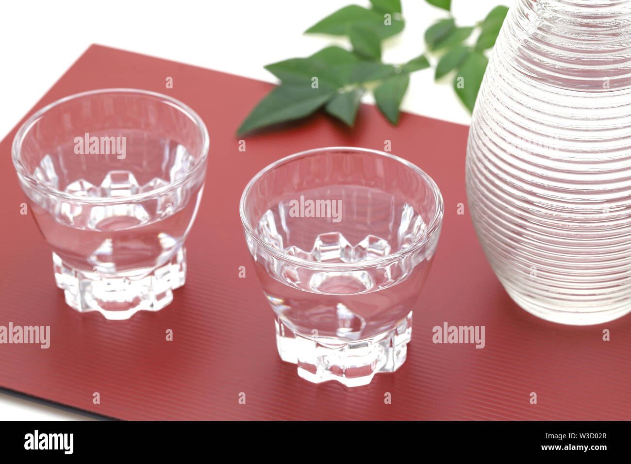 Japanese sake in transparent glass cup and jar on white background ...