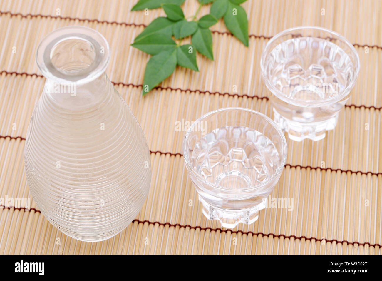 Japanese sake in transparent glass cup and jar on bamboo table Stock ...