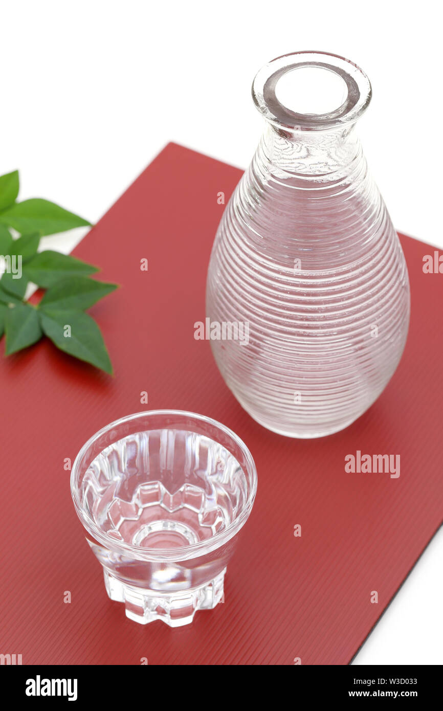 Japanese sake in transparent glass cup and jar on white background ...