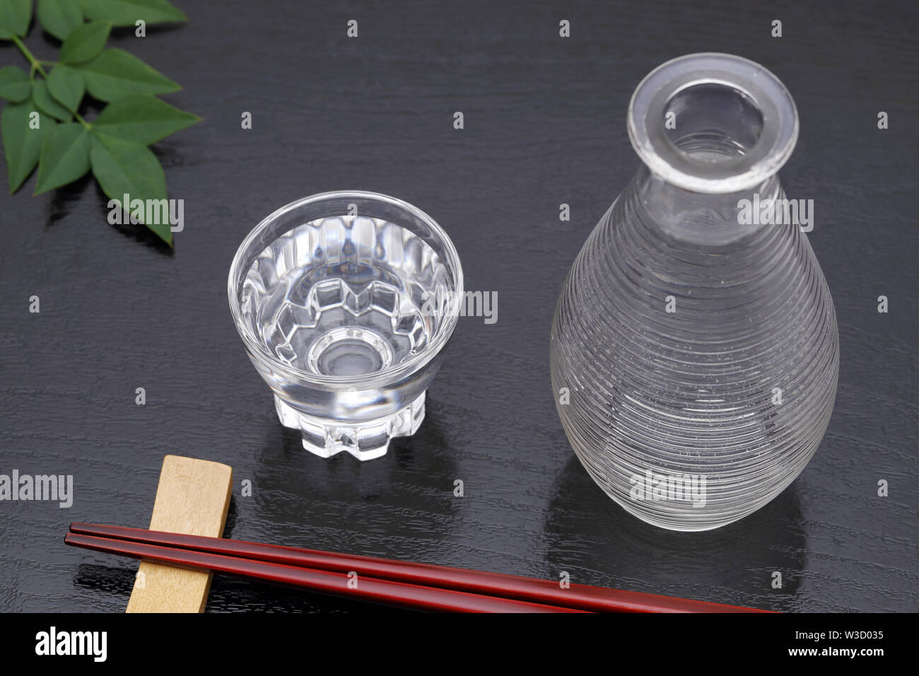 Japanese sake in transparent glass cup and jar on black background ...