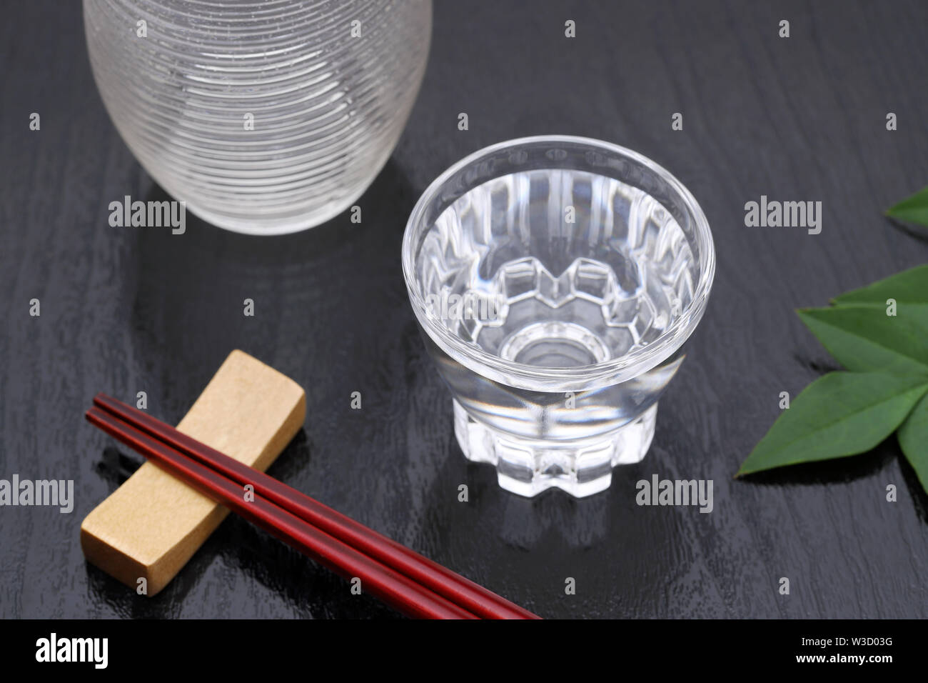 Japanese sake in transparent glass cup and jar on black background ...