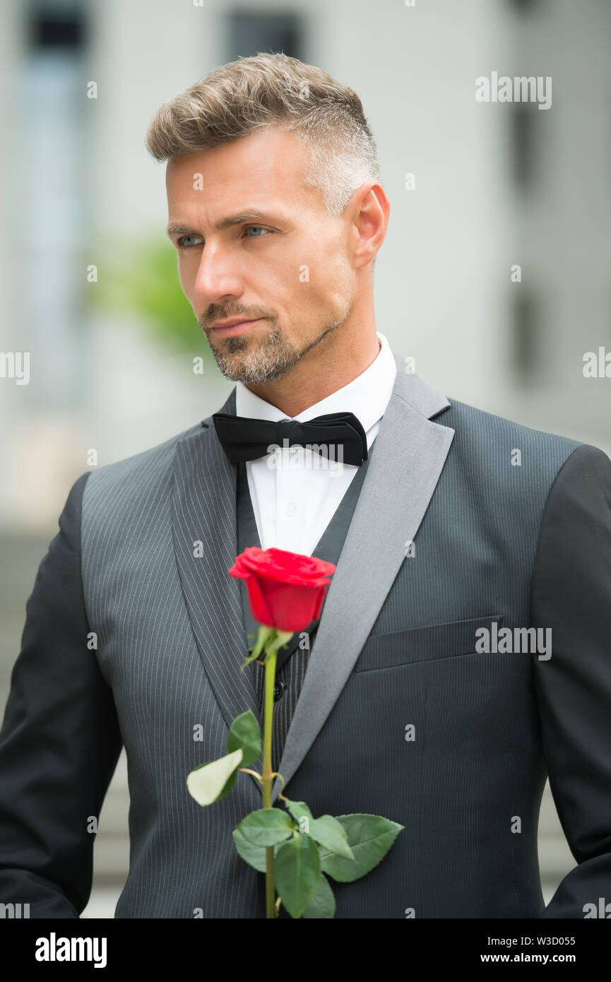 Todays valentines day. Handsome guy holding valentines flowering gift ...