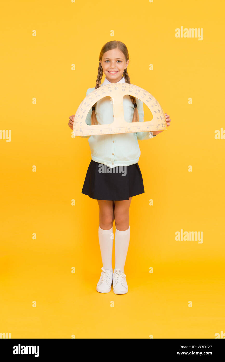 Exploring the properties of protractor in the lesson. Cute girl holding ...