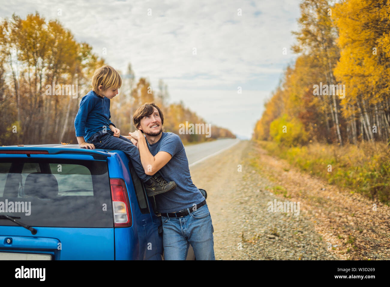 Dad and son are resting on the side of the road on a road trip. Road ...