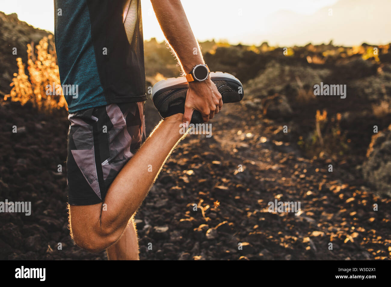 Male runner stretching leg and feet and preparing for running outdoors ...
