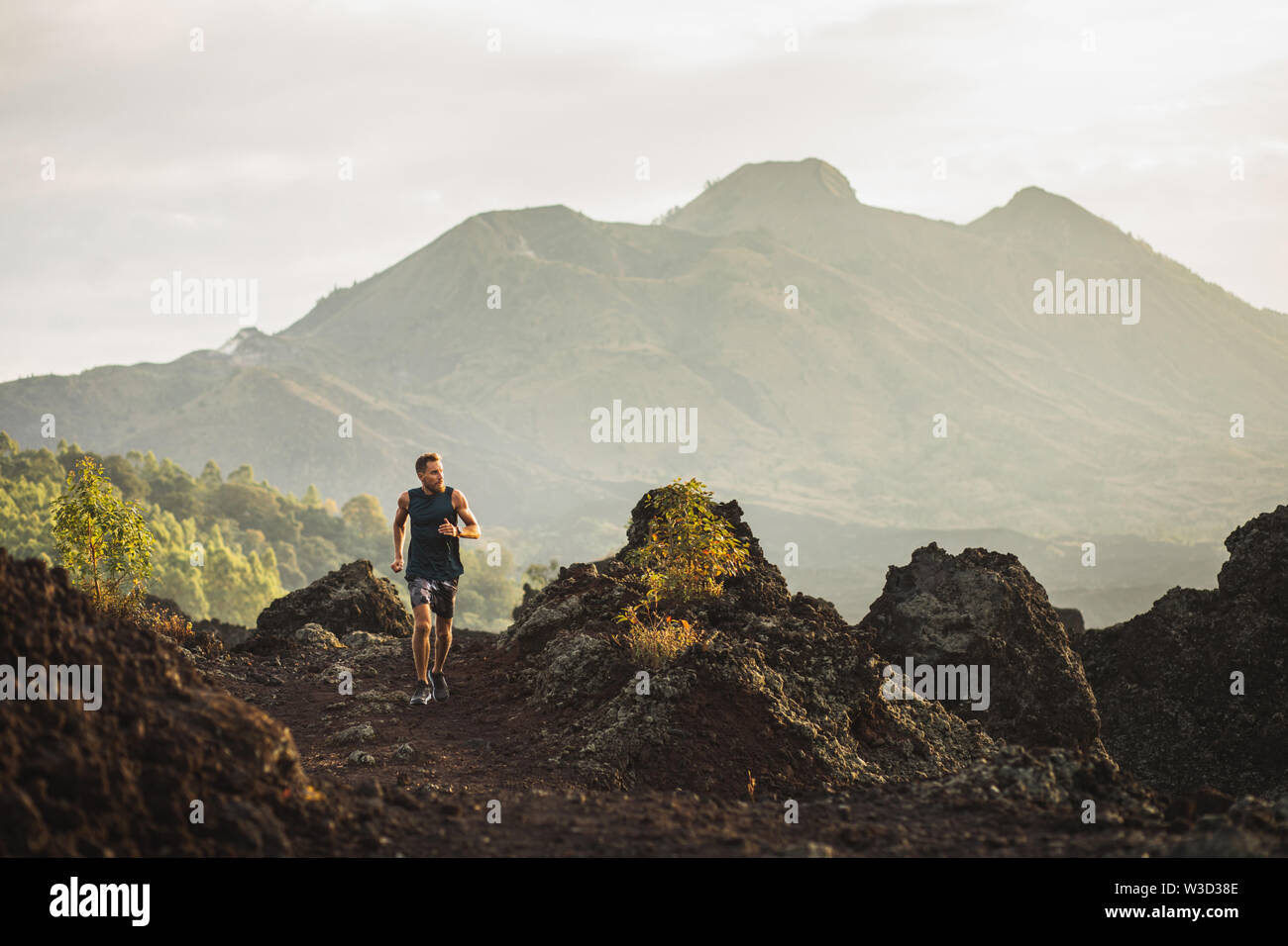 Young athlete man trail running in mountains in the morning. Amazing ...
