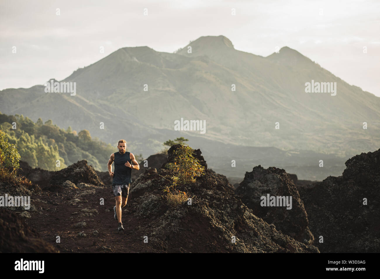 Young athlete man trail running in mountains in the morning. Amazing ...