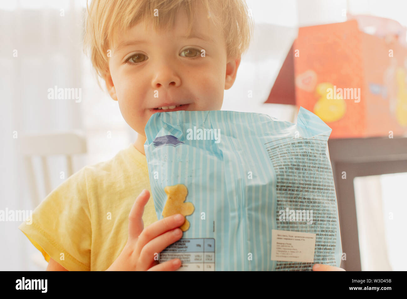 Cute child with pack of chips Stock Photo - Alamy