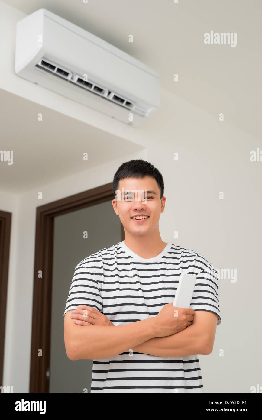 Air conditioner inside unit with man operating remote controller. / Air ...