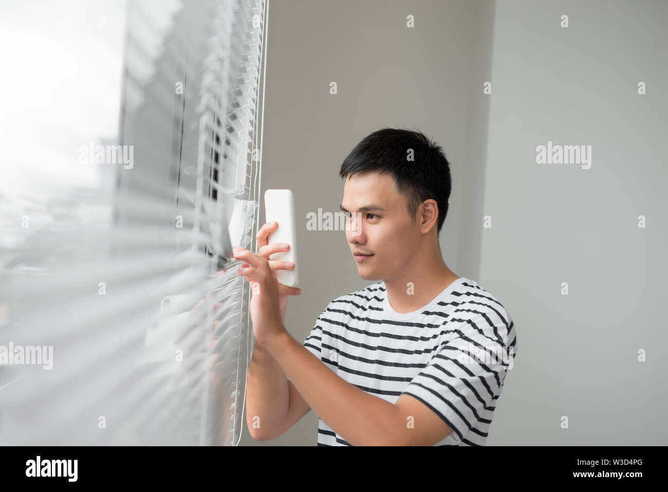 Handsome young man taking photo through the window with mobile Stock ...