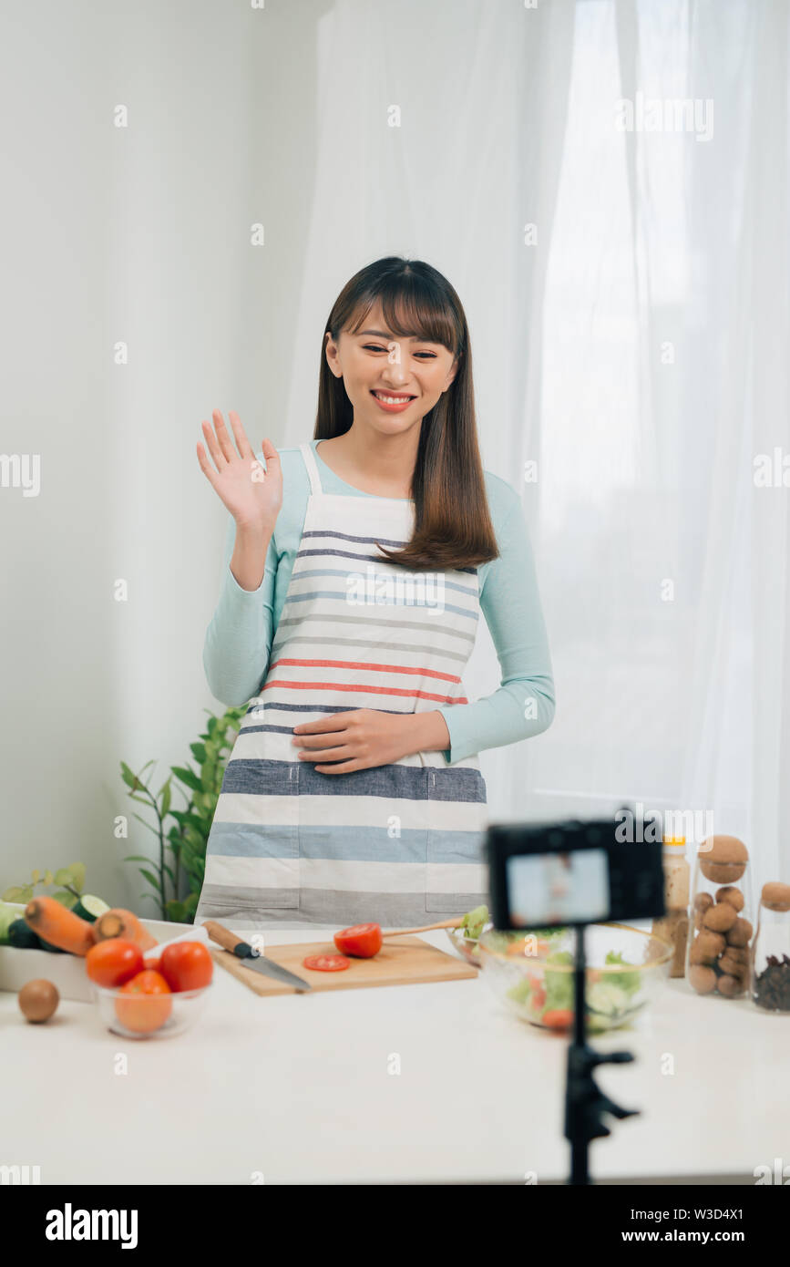 Online cooking classes. Food blogging. Woman preparing meal and ...