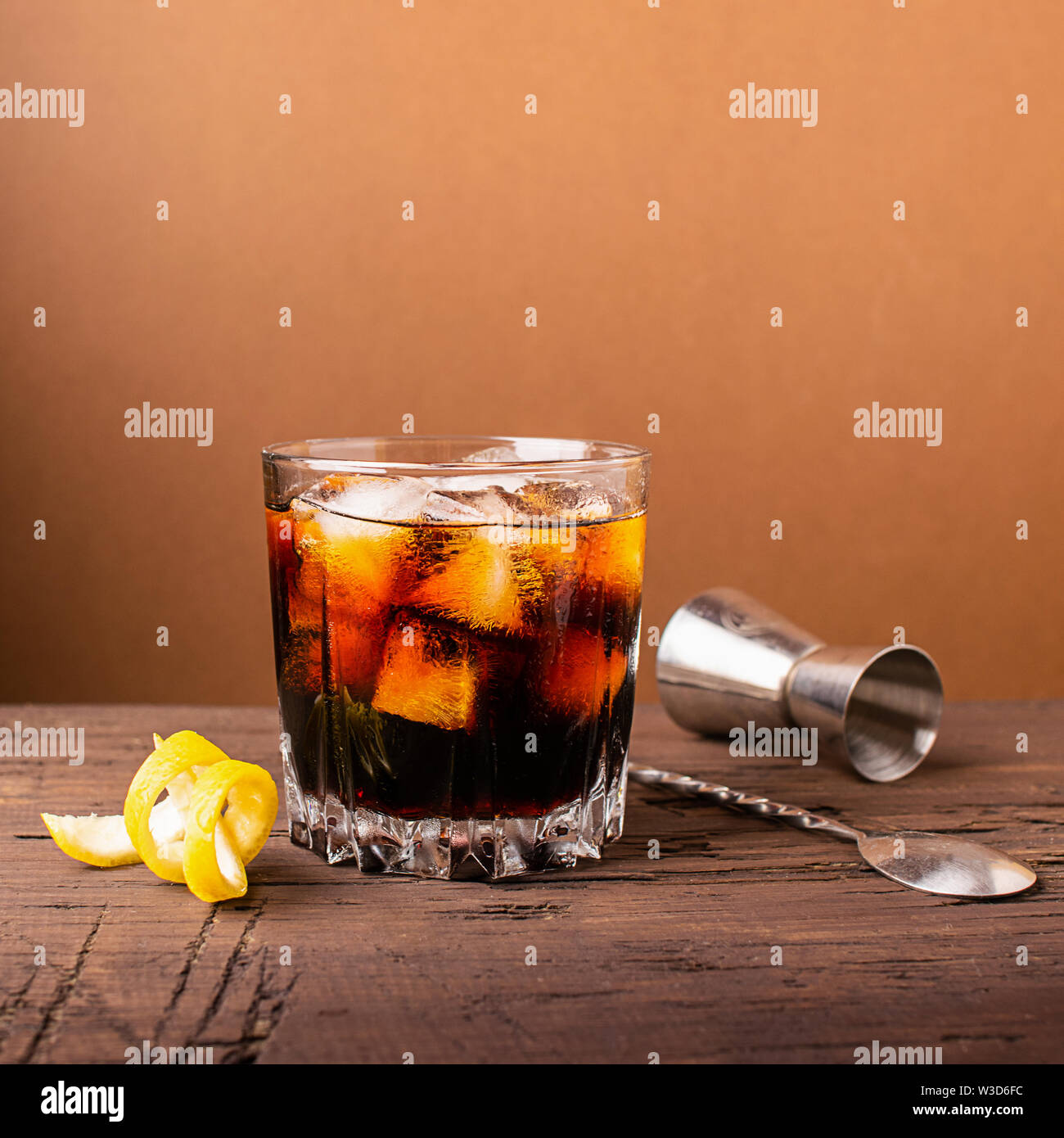 Strong alcoholic drink of brandy whiskey in a glass with ice cubes dark ...