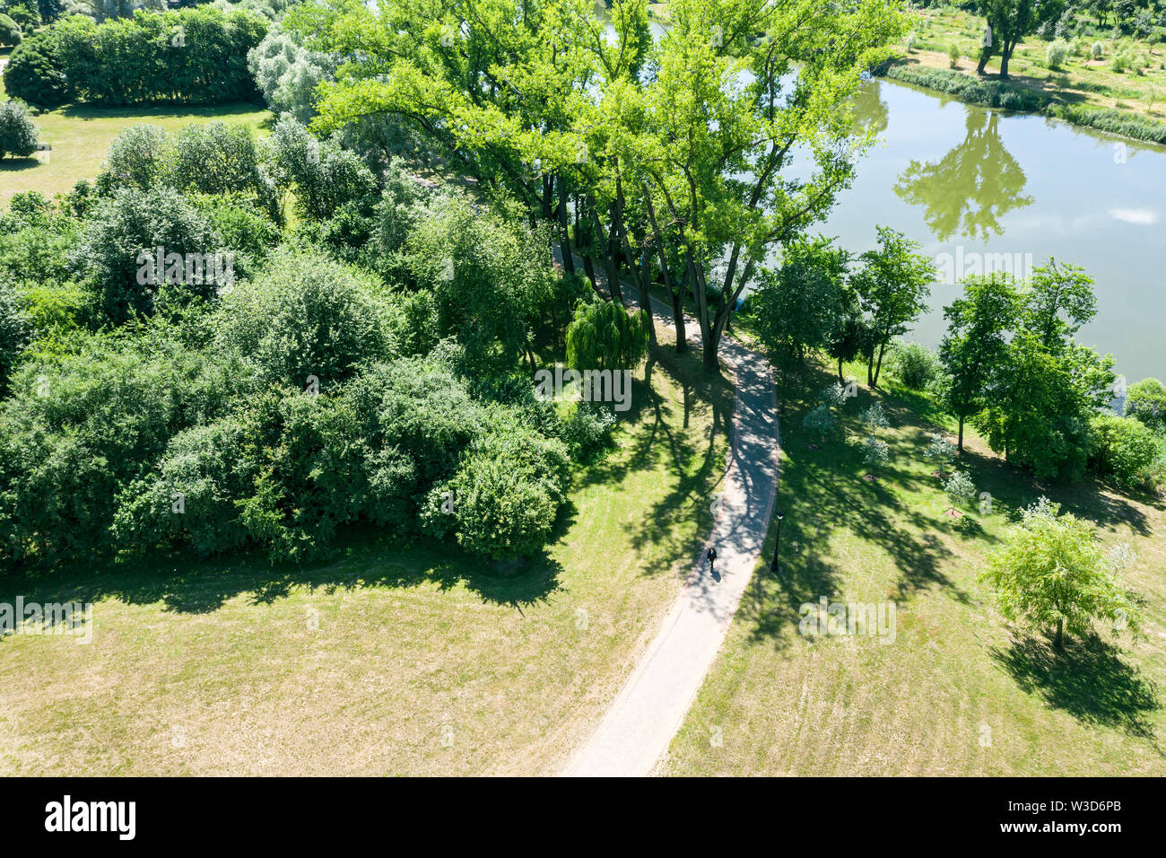park landscape in summer. walking path leading to small lake, top view ...