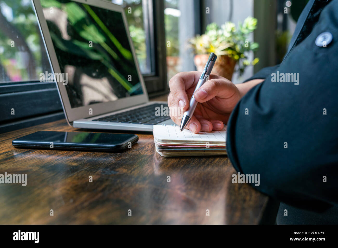 Human hand holding pen and writing notebook Stock Photo - Alamy