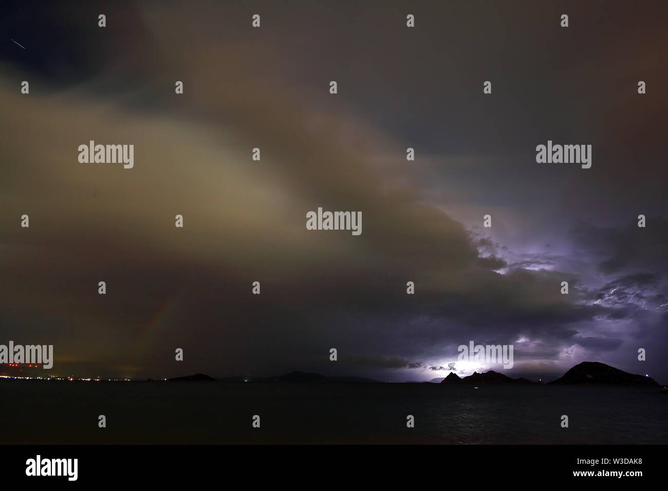 view of lightning strike over a rural farm field, lightning strikes the ...